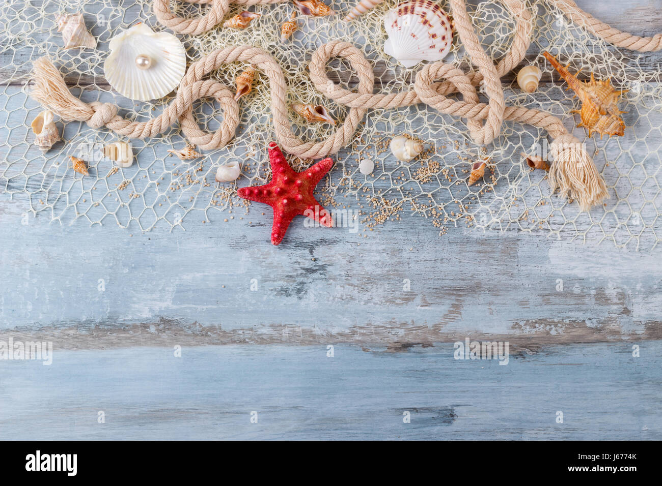 sea shells in a fishnet,on wooden board, summer vacation background ...