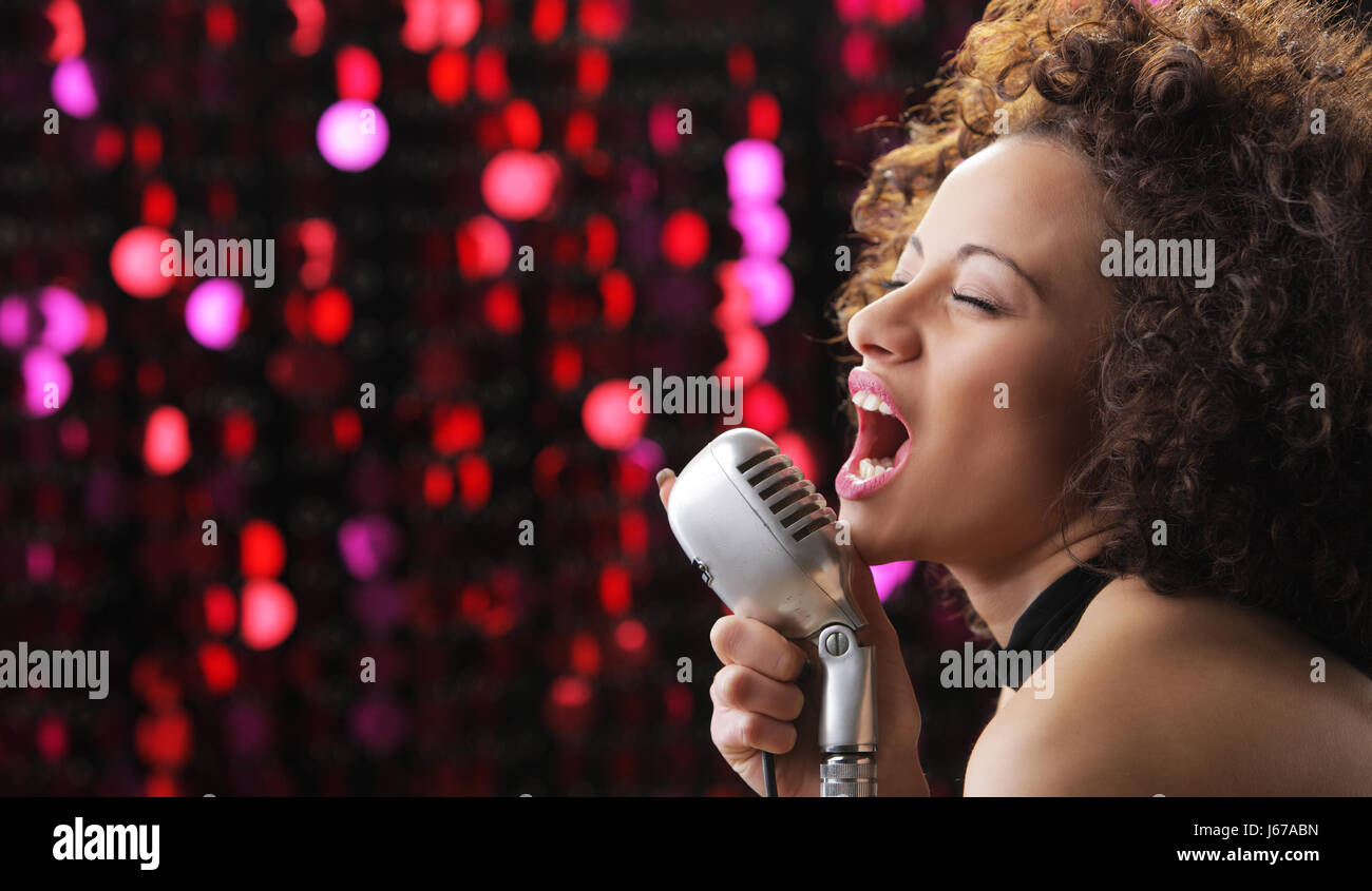 Young female singer with brown curly hair singing a song Stock Photo ...