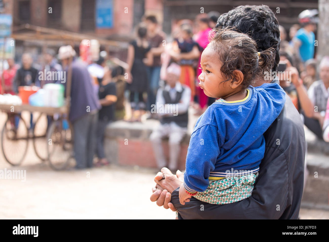 Kathmandu, Nepal - Apr 15, 2016: Father and his child watching passing ...