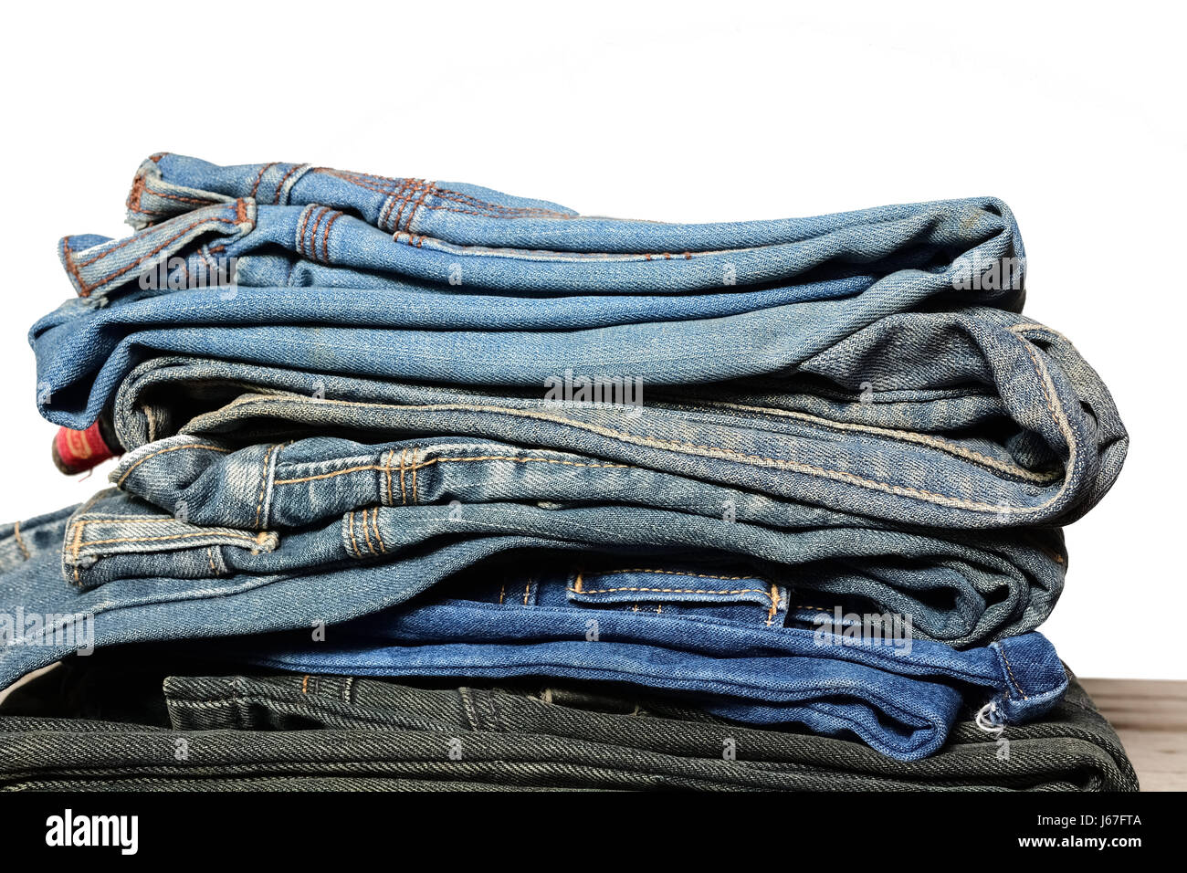 stack of blue jeans on white background Stock Photo - Alamy