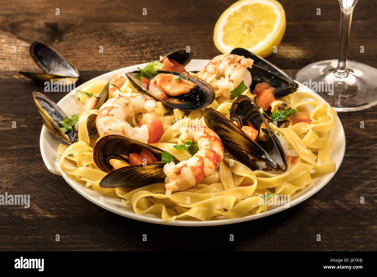 A photo of a ready to eat seafood pasta dish with mussels and shrimps ...