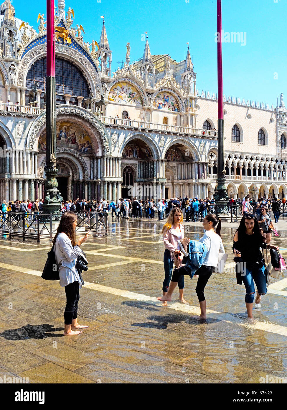 Tourists wading in flooded St. Mark's Square in Venice Stock Photo - Alamy