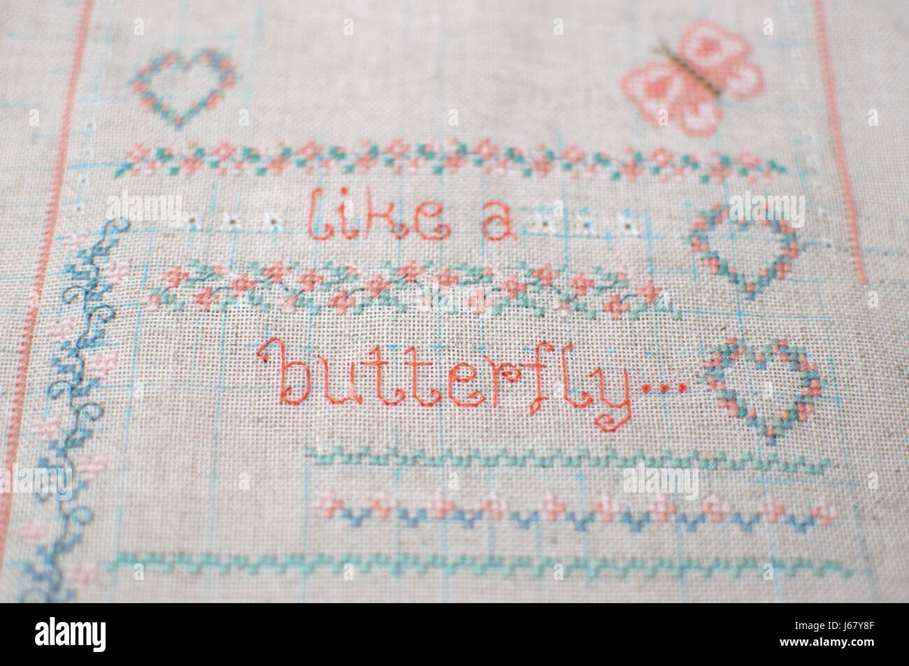 Cross-stitch embroidery on linen. Sampler with floral patterns, hearts ...