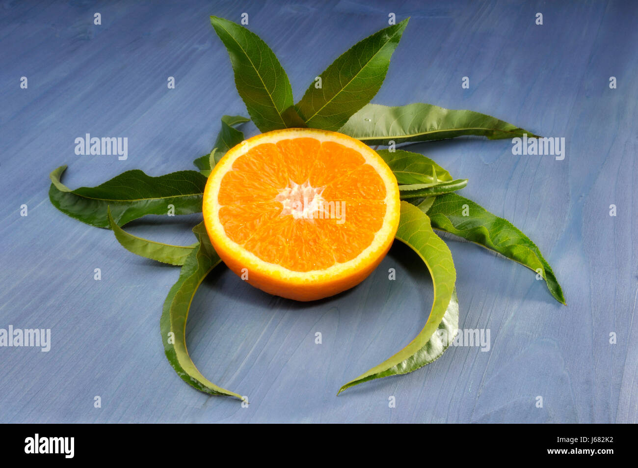 half an orange with leaves Stock Photo - Alamy