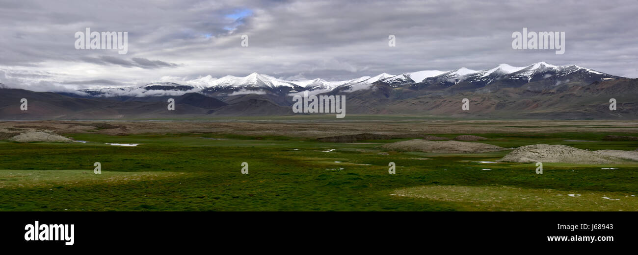 High mountain valley of Tibet in summer: chains of high peaks with snow ...