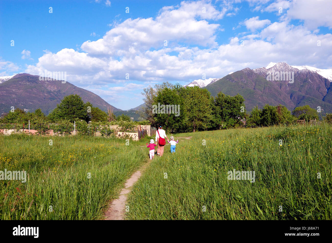 walk go going walking spring meadow grass lawn green familiy family woman blue Stock Photo - Alamy