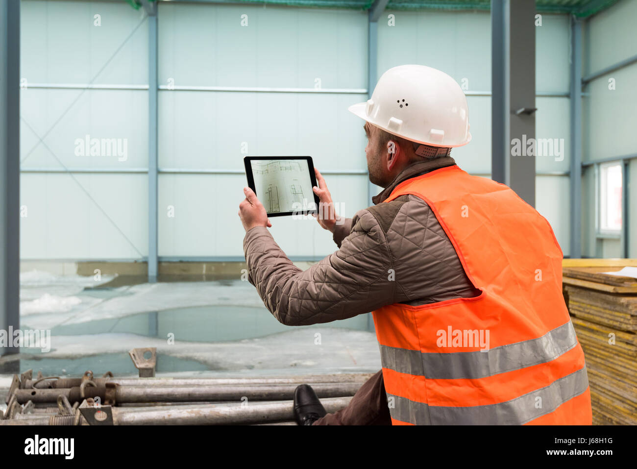 Construction supervisor checks the interior of a new warehouse being ...