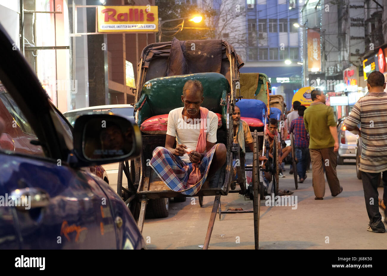 A hand rickshaw puller waits for passengers in his rickshaw in Kolkata ...