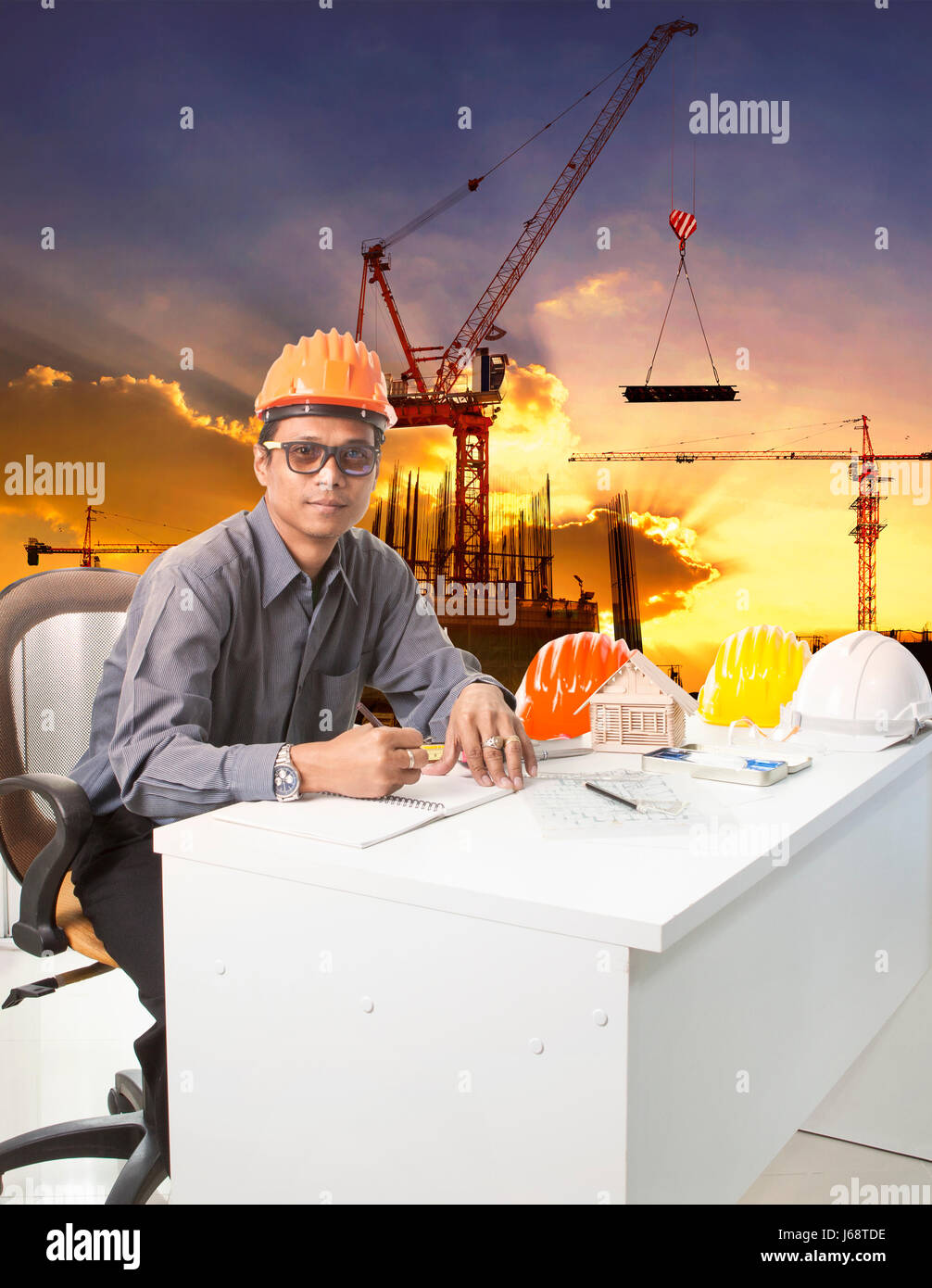 engineering man with safety helmet working table against building ...