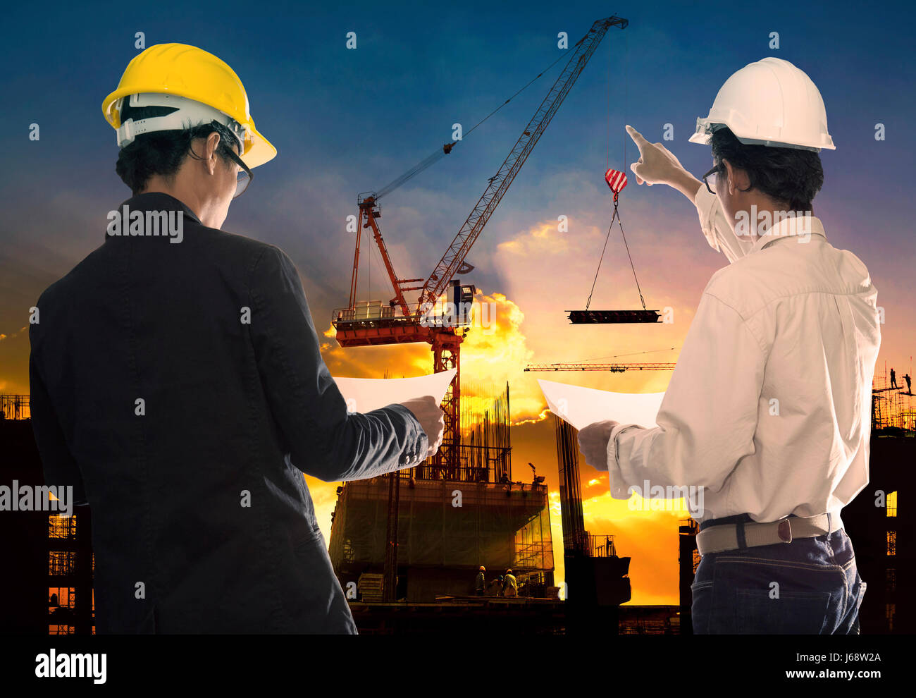 two civil engineer working in building construction site against ...