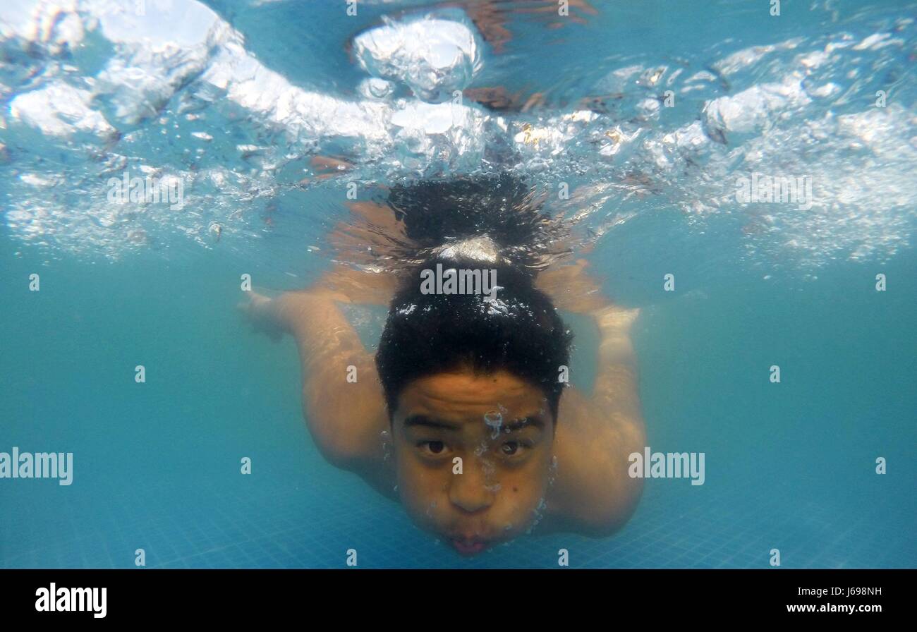 Bhaktapur. 20th May, 2017. A kid swims underwater in a swimming pool to ...