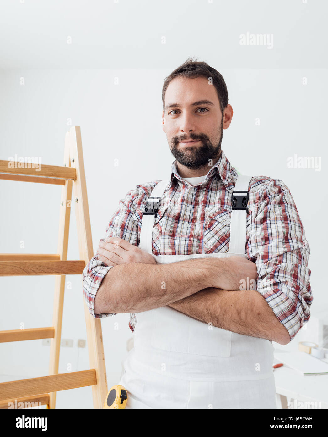 Confident professional painter posing with arms crossed, home ...