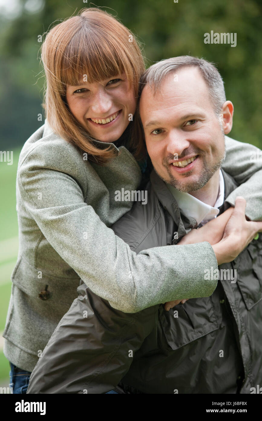 woman hugging a man running in park Stock Photo - Alamy