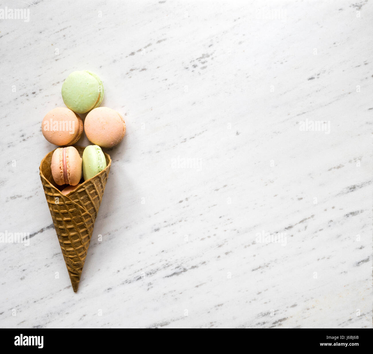 Colorful macaron in ice cream cone of waffle on marble background Stock ...