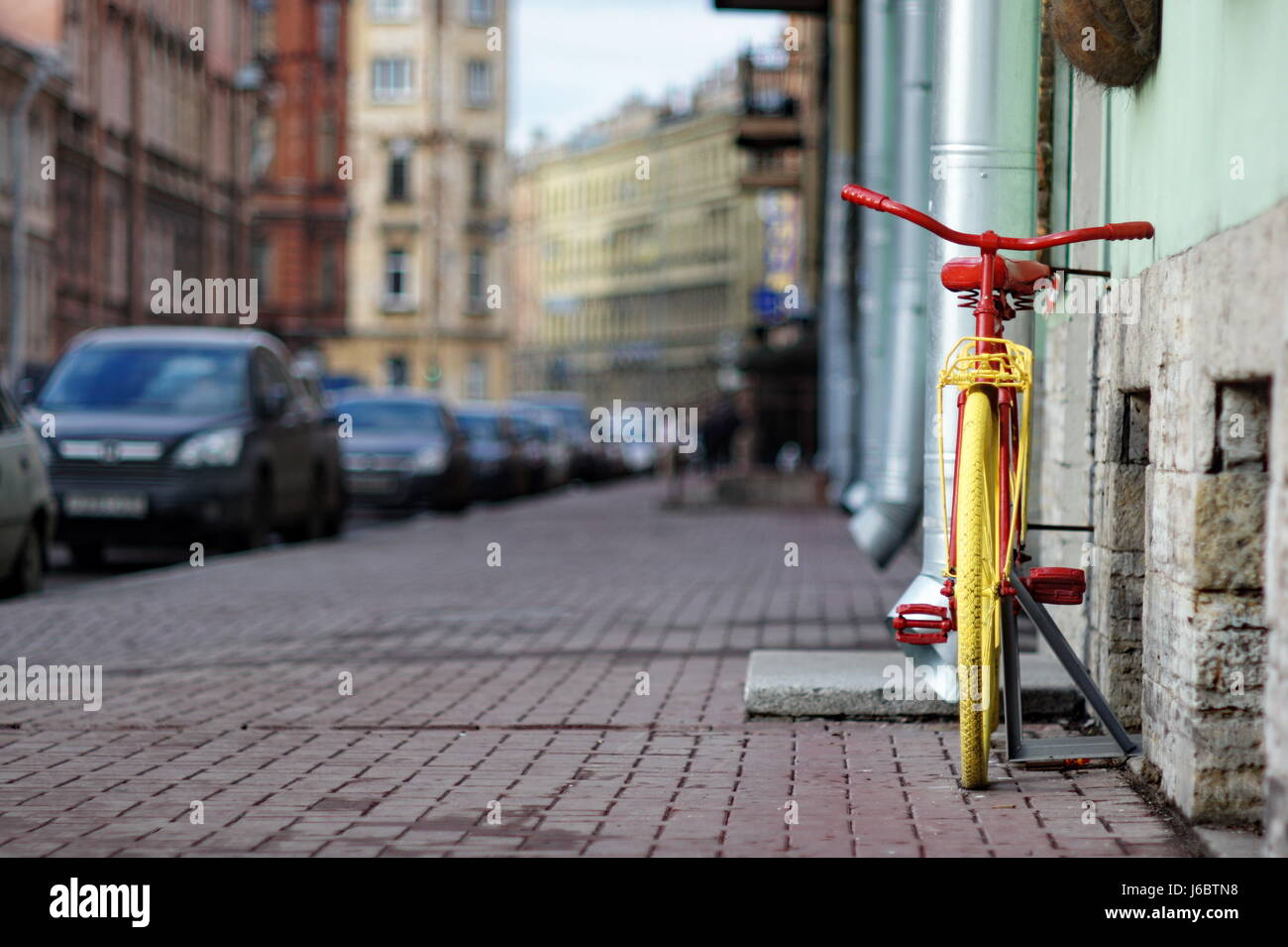 old yellow bicycle stands at the walls the city houses Stock Photo - Alamy