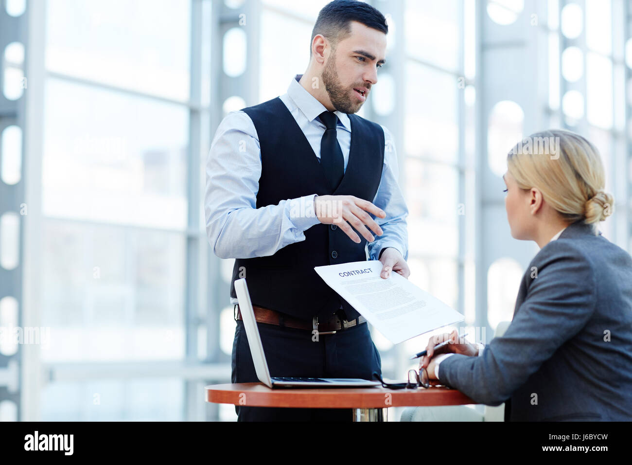 Business leader showing his secretary new contract and explaining its ...