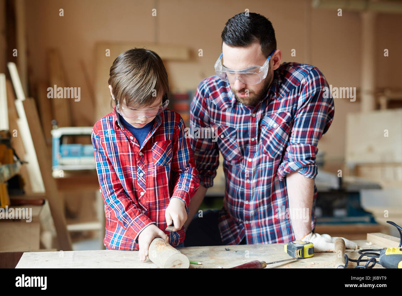 Creative man and little boy wood crafting together Stock Photo - Alamy