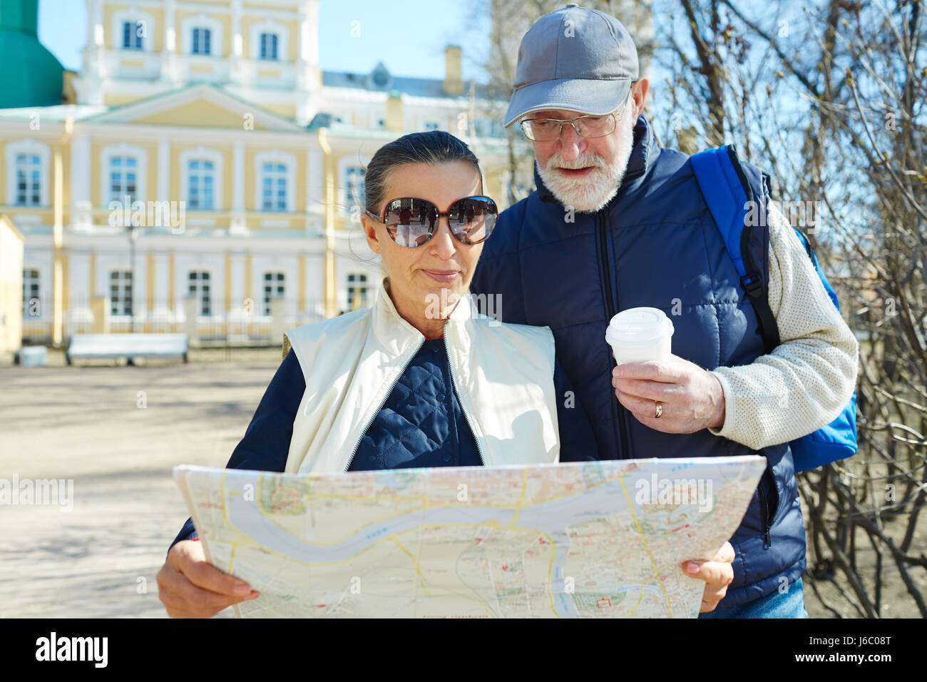 Contemporary tourists looking at guide Stock Photo - Alamy