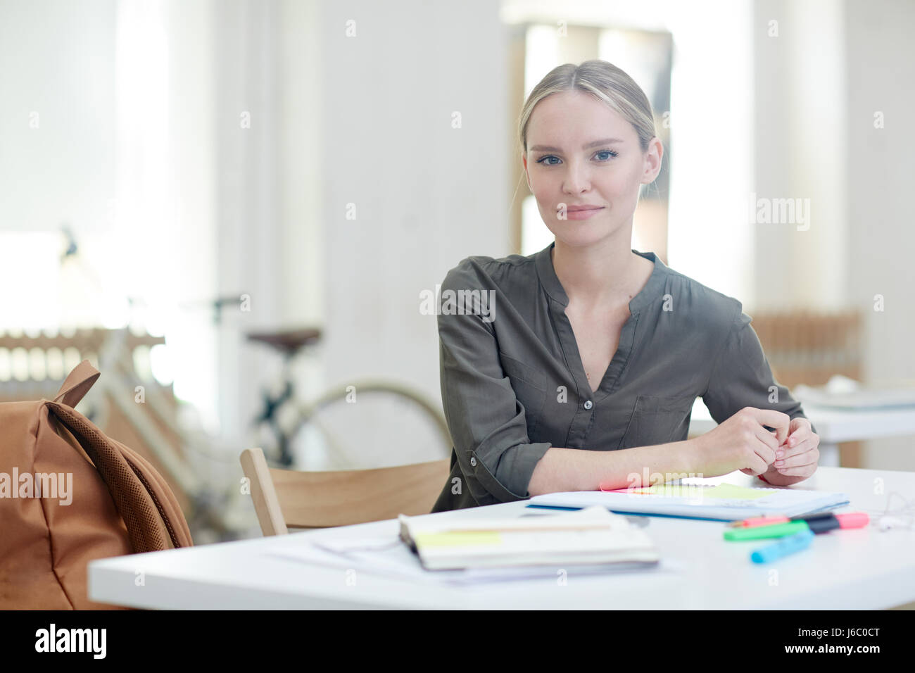 Contemporary student sitting by desk in classroom Stock Photo - Alamy