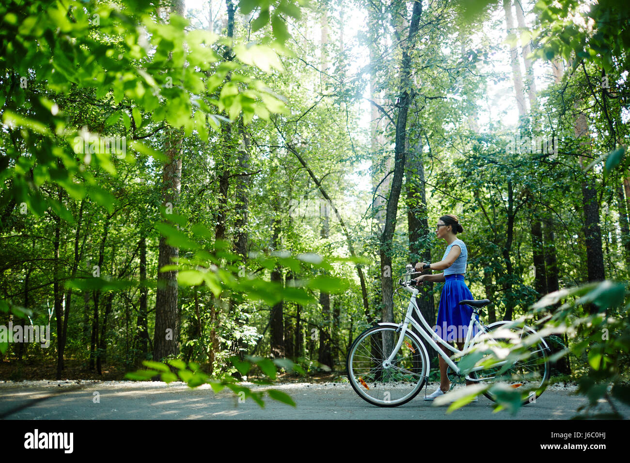 Active girl with her cycle walking in park Stock Photo - Alamy