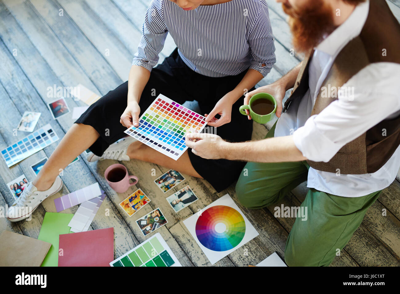 Team of creative designers discussing project, choosing color scheme ...