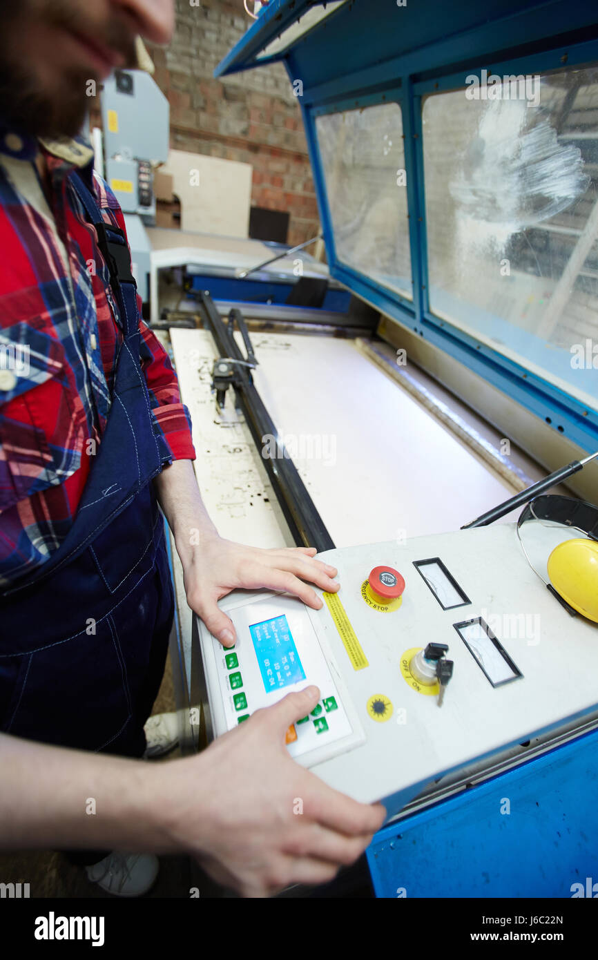 Portrait of unrecognizable worker operating machines in factory ...