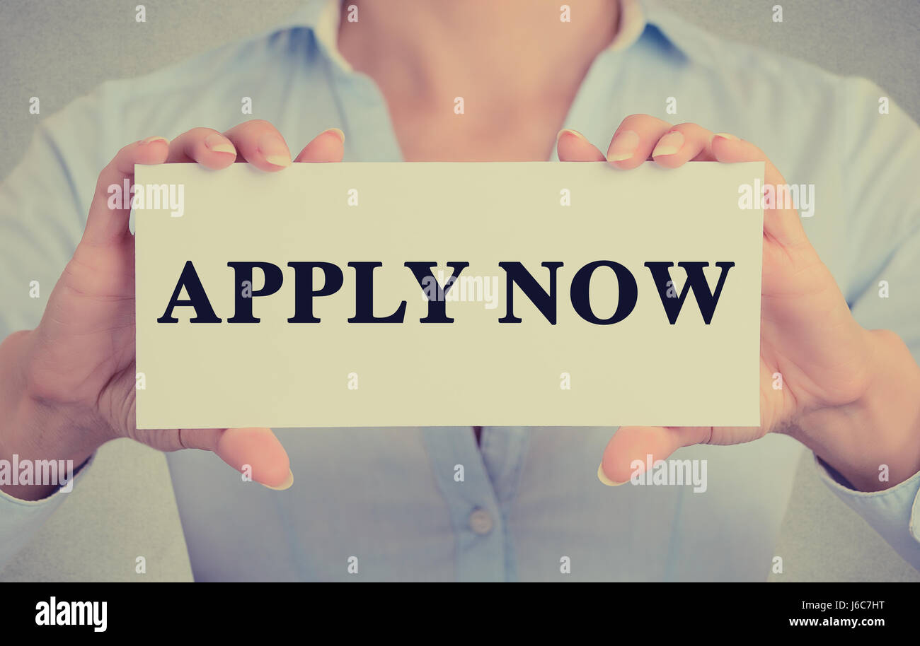 Closeup businesswoman hands holding white card sign with apply now text ...