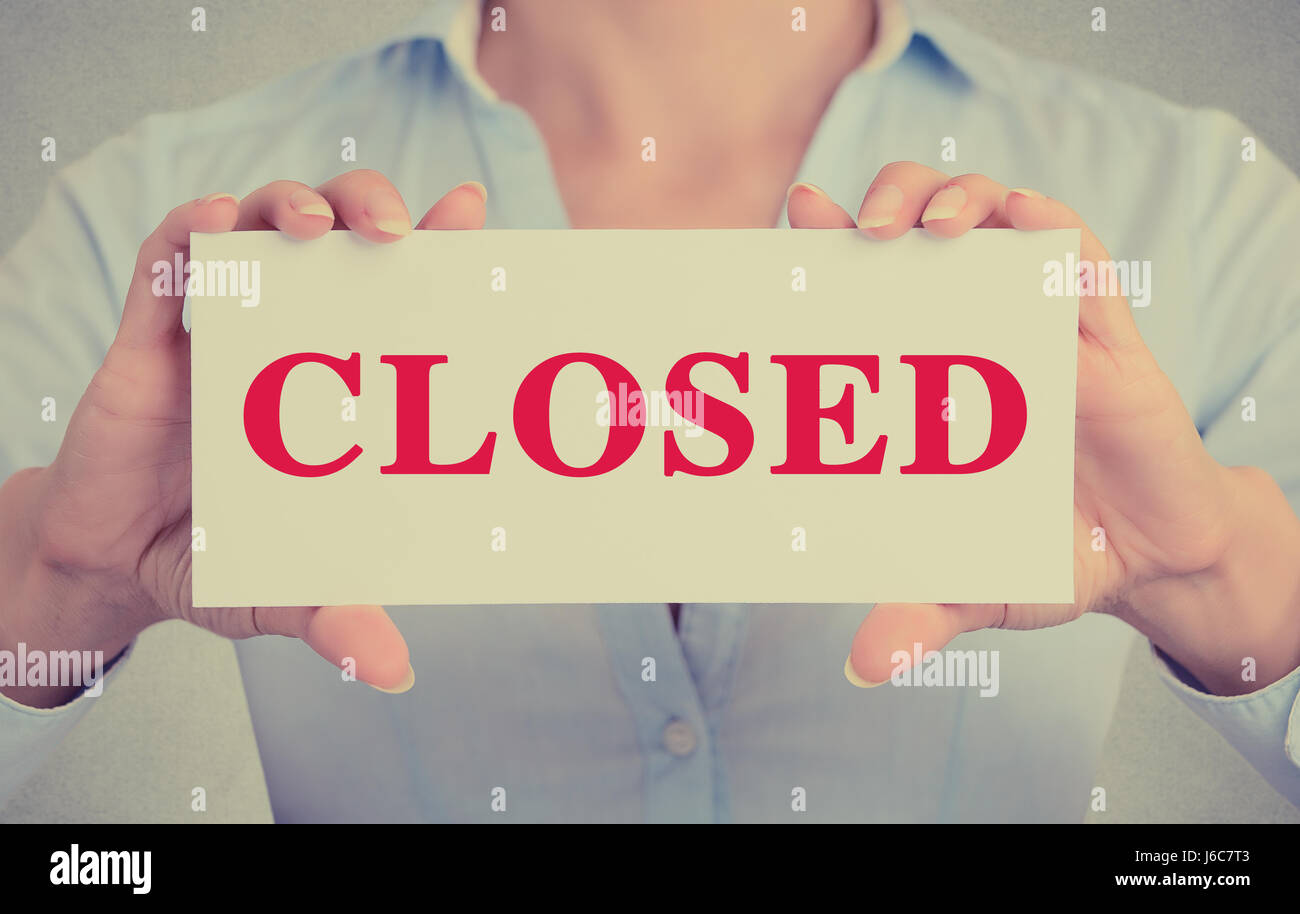 Closeup businesswoman hands holding white card sign with closed text ...