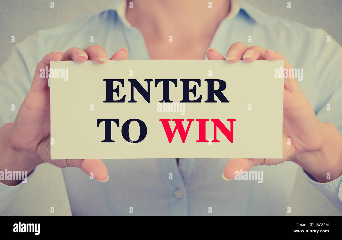 Businesswoman hands holding white card sign with enter to win text ...