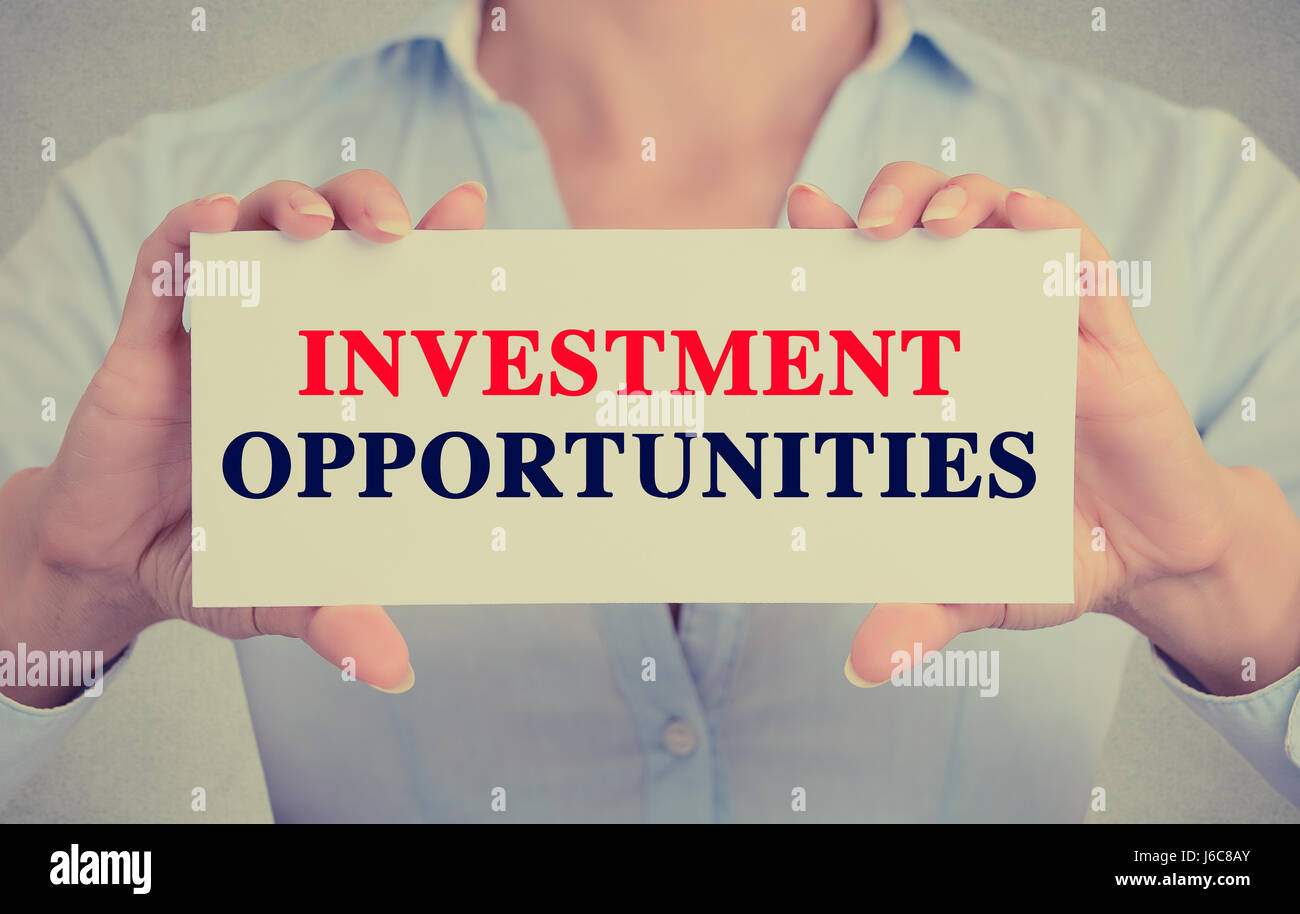 Businesswoman hands holding white card sign with Investment ...