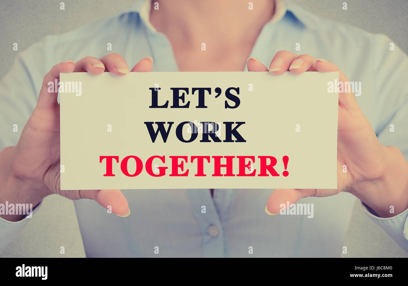 Businesswoman hands holding white card sign with let's work together ...