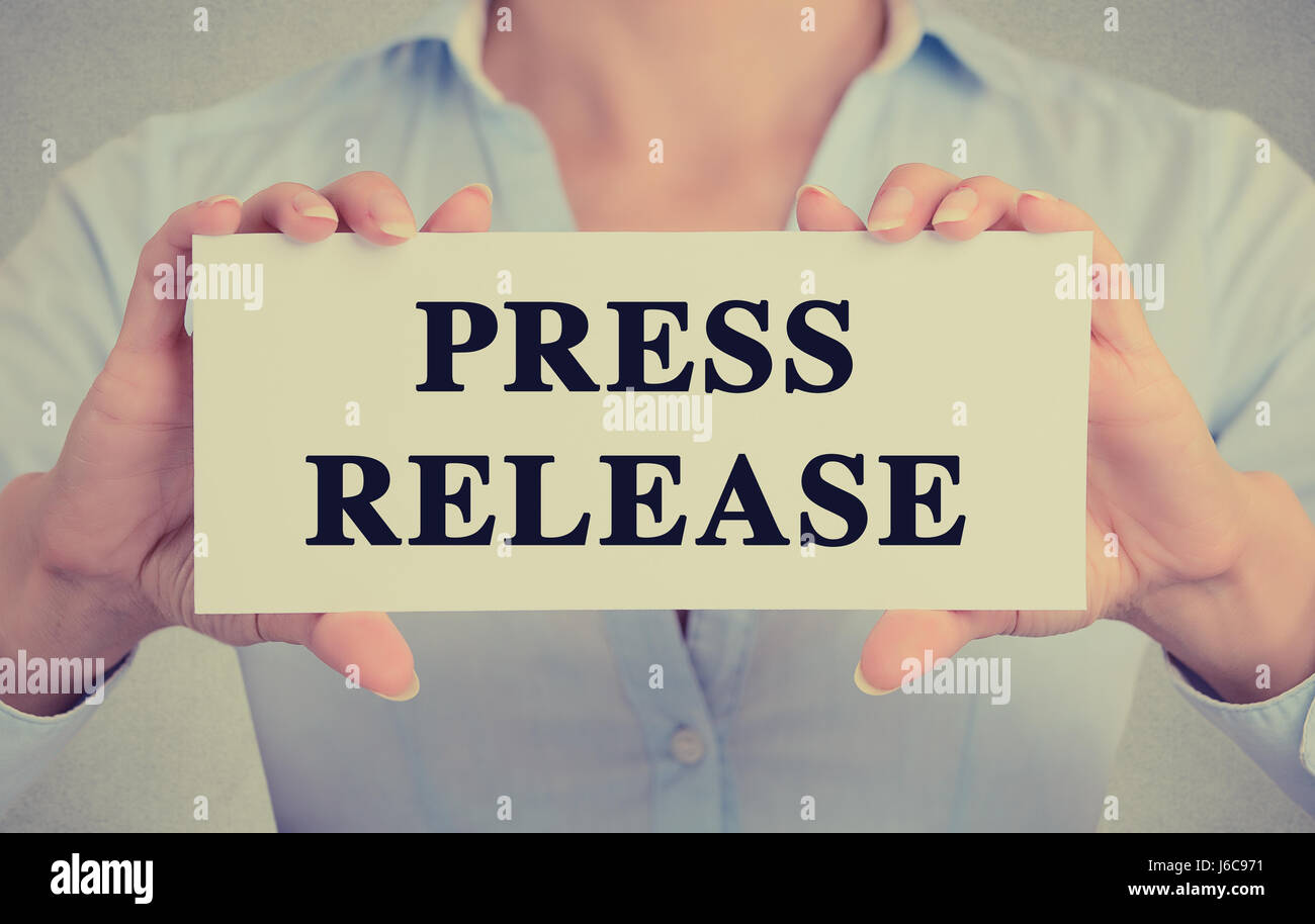 Businesswoman hands holding white card sign with press release text ...
