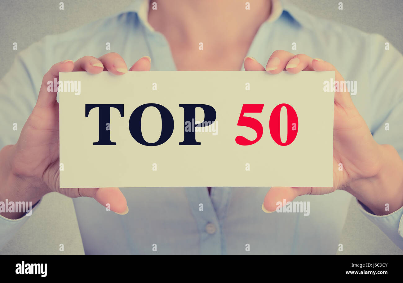 Closeup businesswoman hands holding white card sign with top 50 text ...