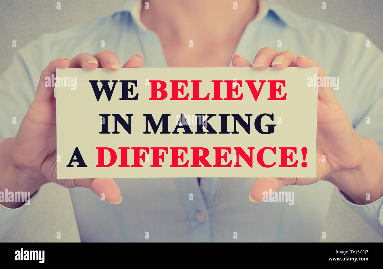 Businesswoman hands holding white card sign with We Believe in Making a ...