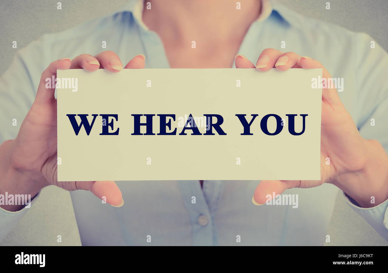 Businesswoman hands holding white card sign with we hear you text ...