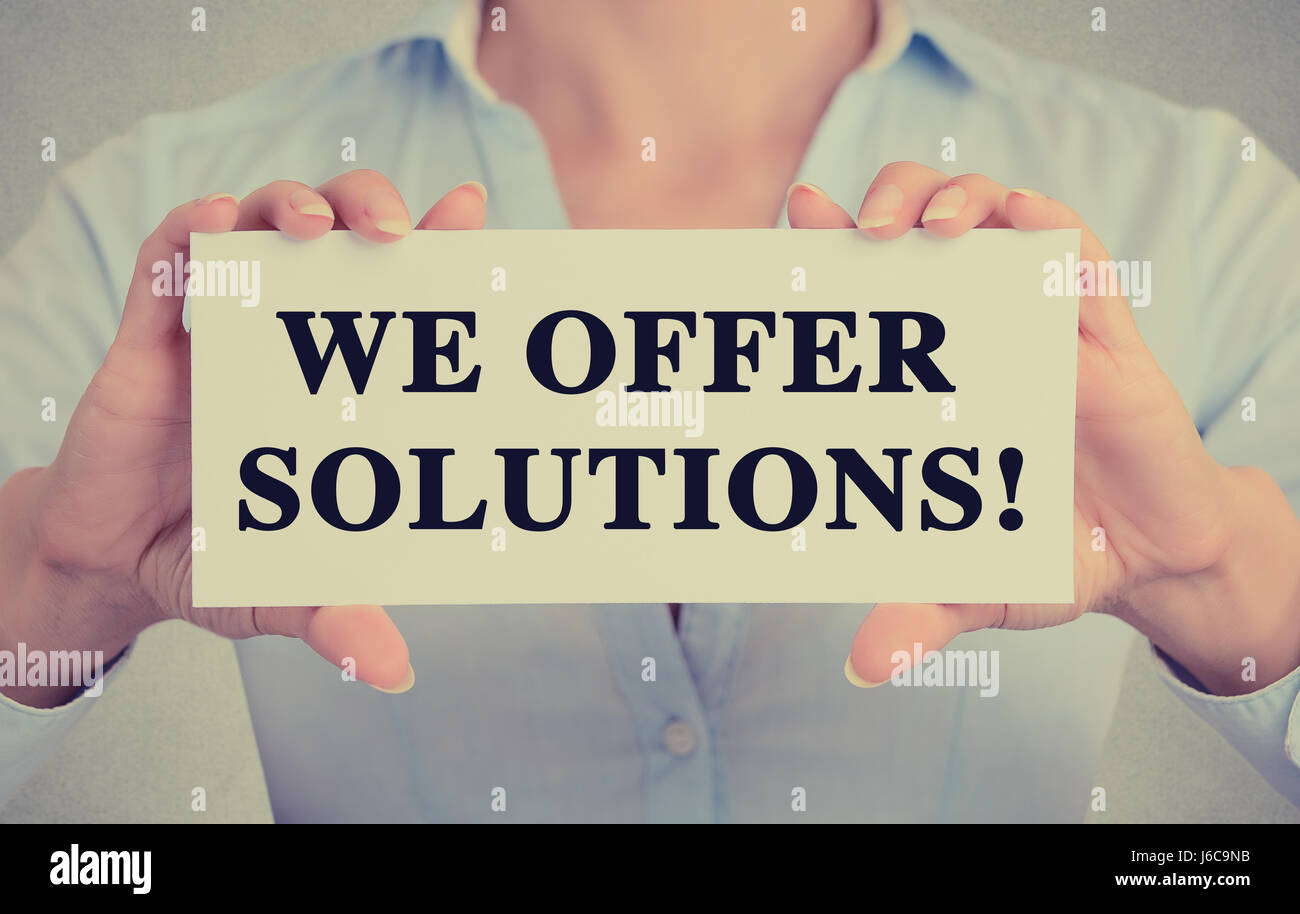 Businesswoman hands holding white card sign with we offer solutions ...