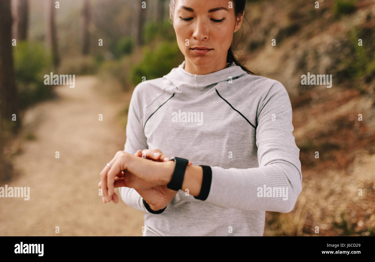 Asian female checking fitness progress on her smart watch. Fit young ...