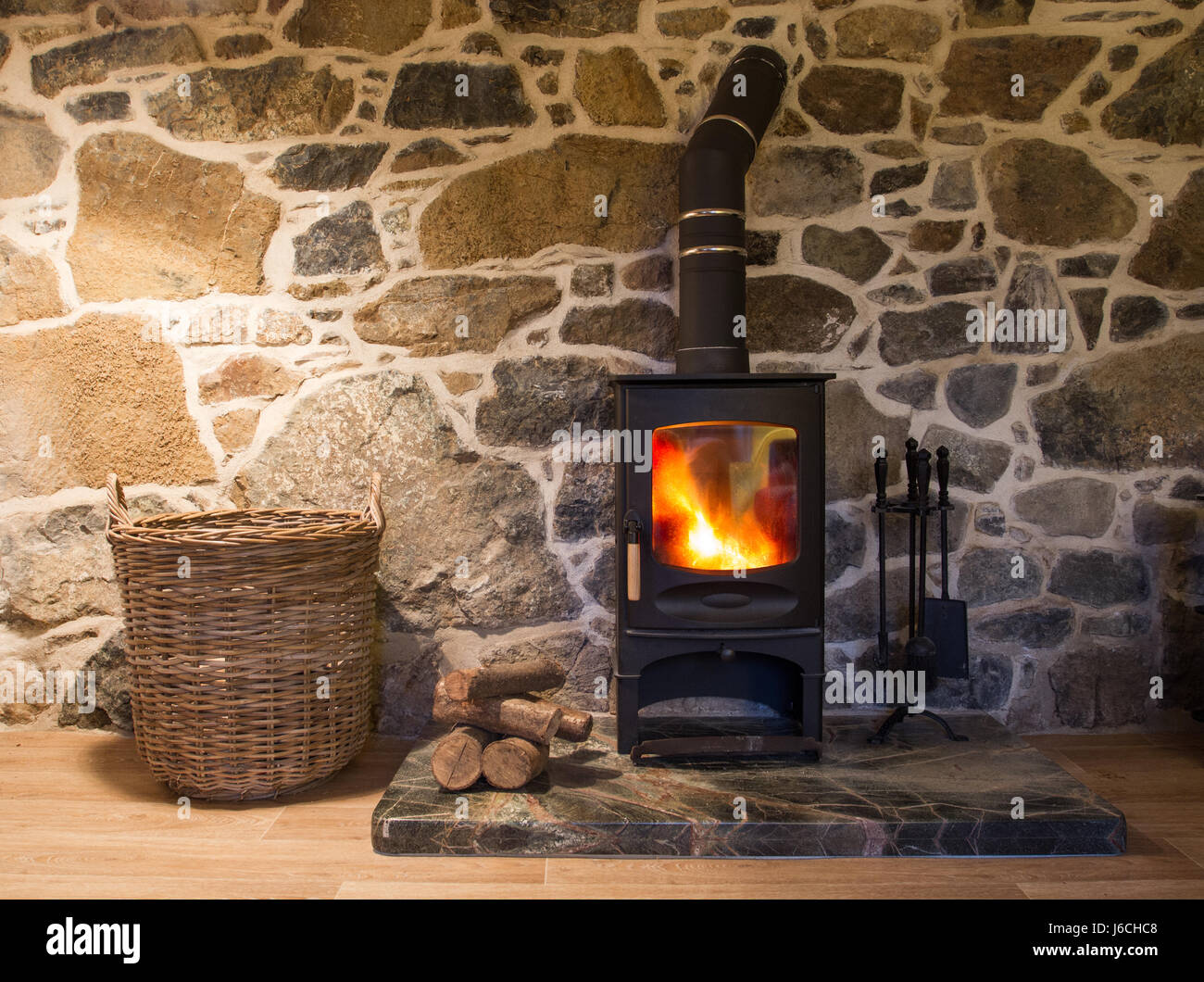 The interior of a cosy, stone walled cottage showing a fireplace scene ...