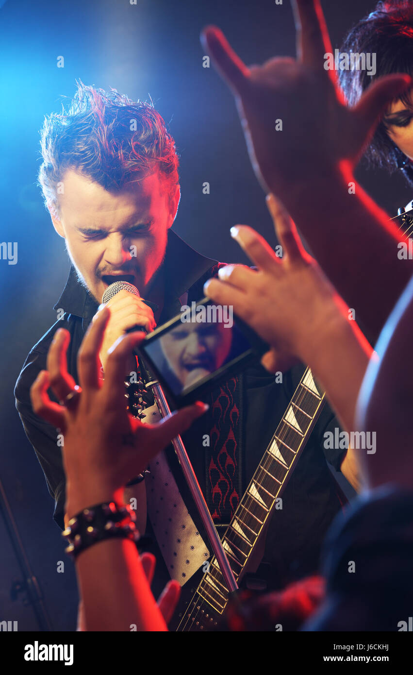 Guitarist singing on stage at a rock concert for his adoring fans Stock ...