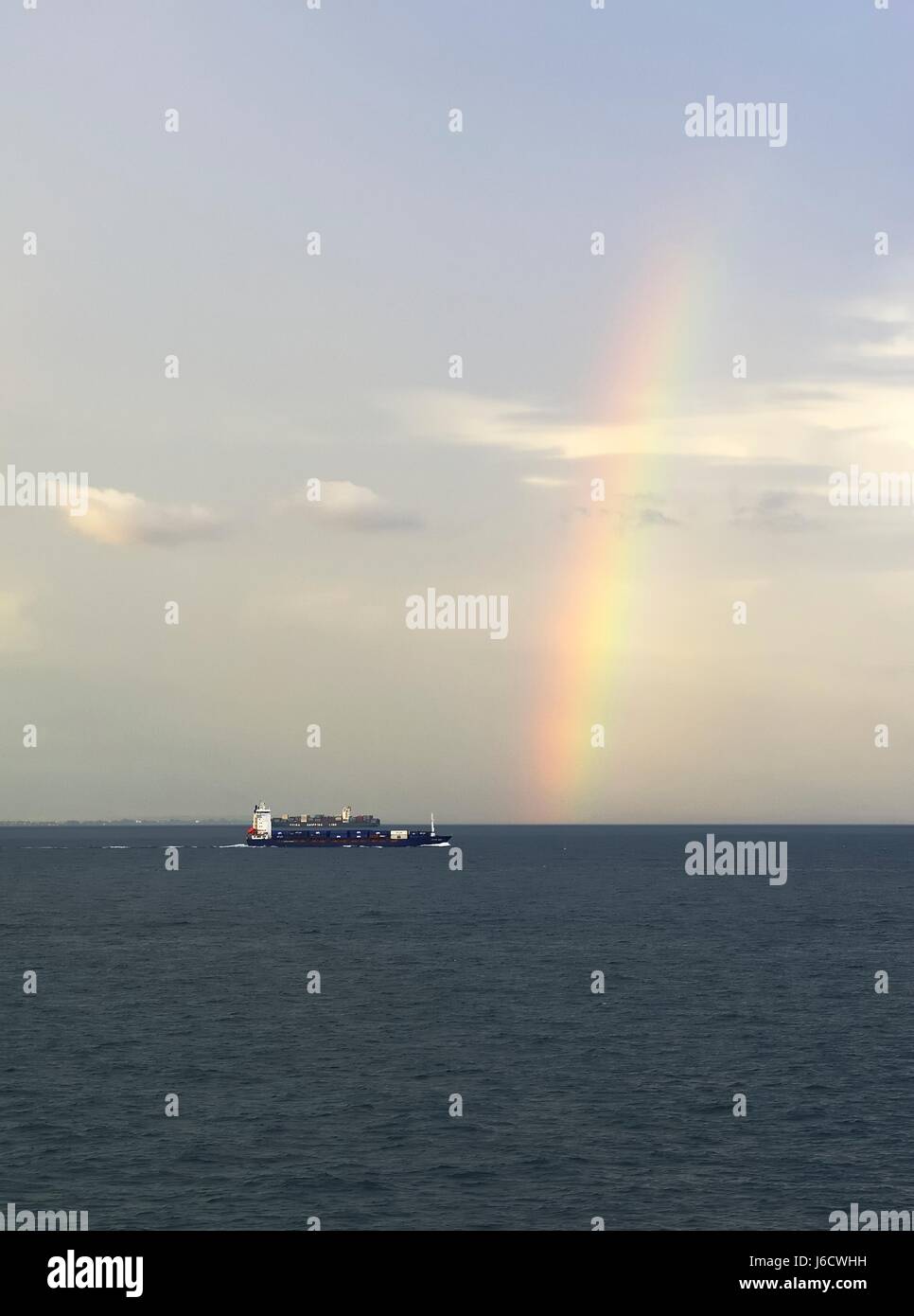 Cargo ship sailing under a Rainbow in the Straits of Malacca in jan ...