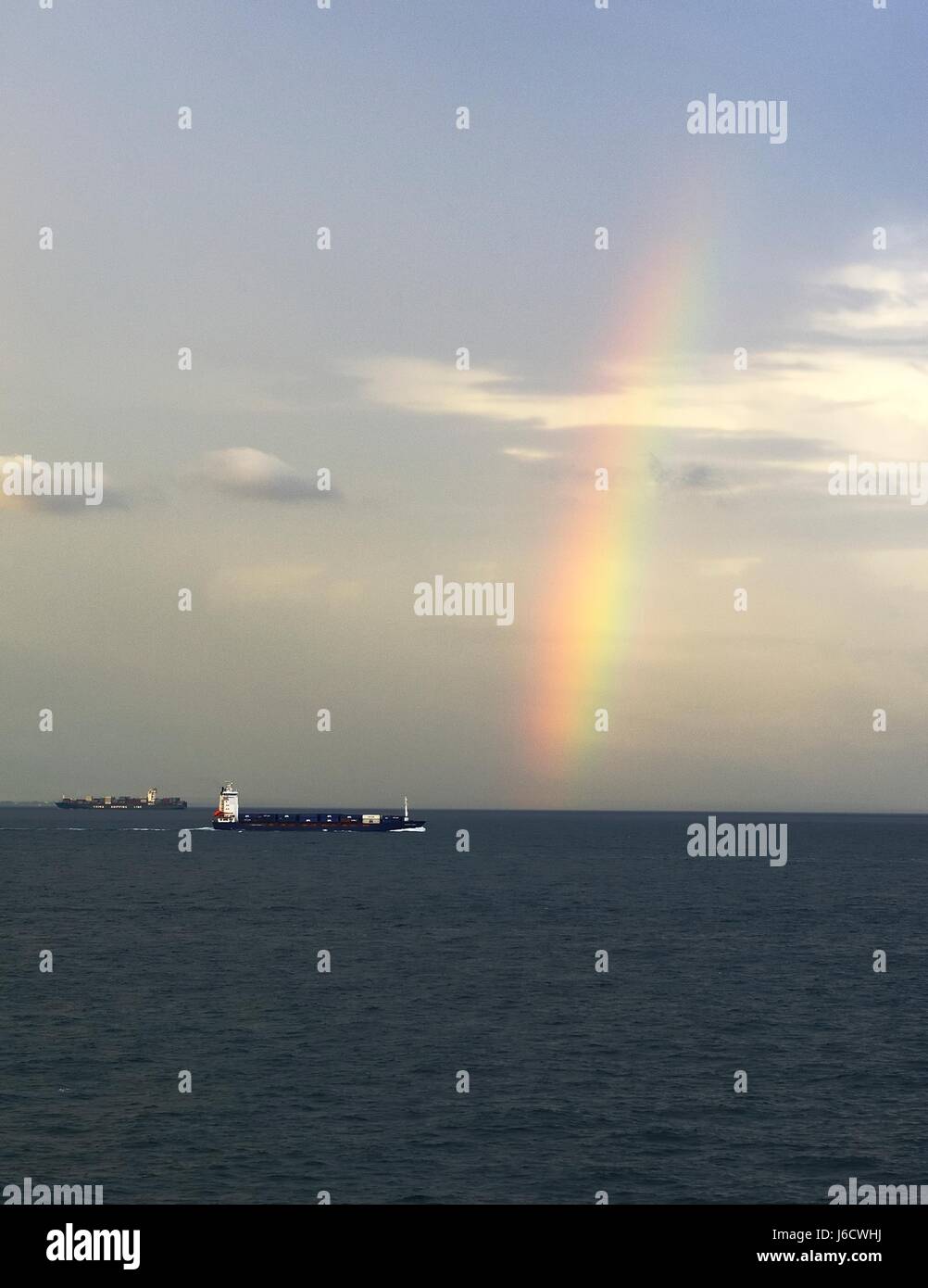 Cargo ship sailing under a Rainbow in the Straits of Malacca in jan ...