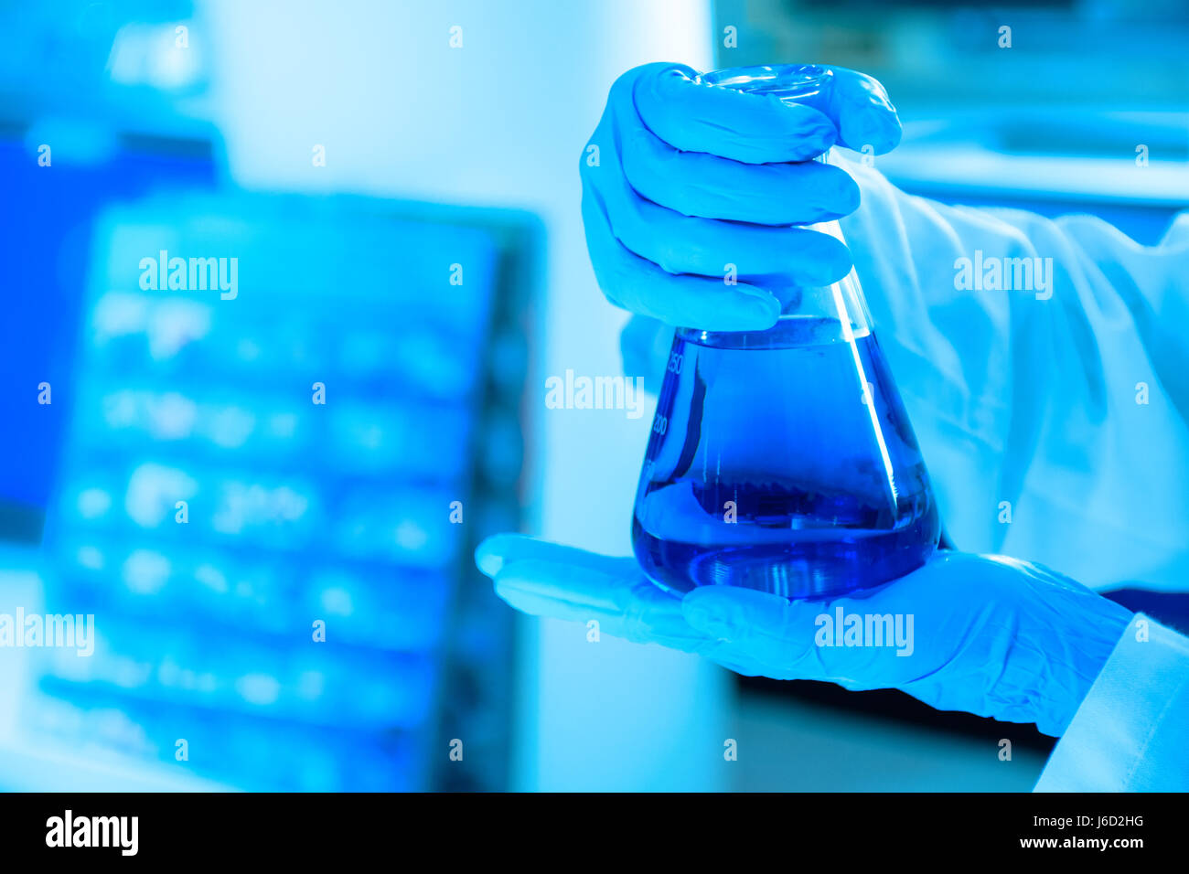 Scientist with sample flask in hand, researching in laboratory Stock ...