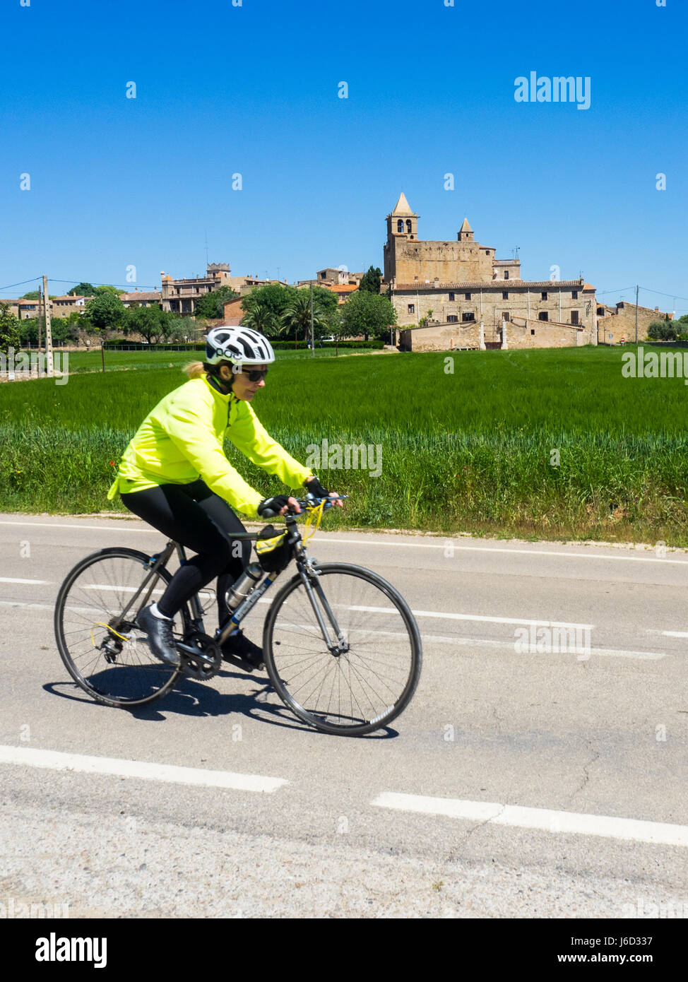 A female touring cyclist riding her titanium bicycle in the countryside ...