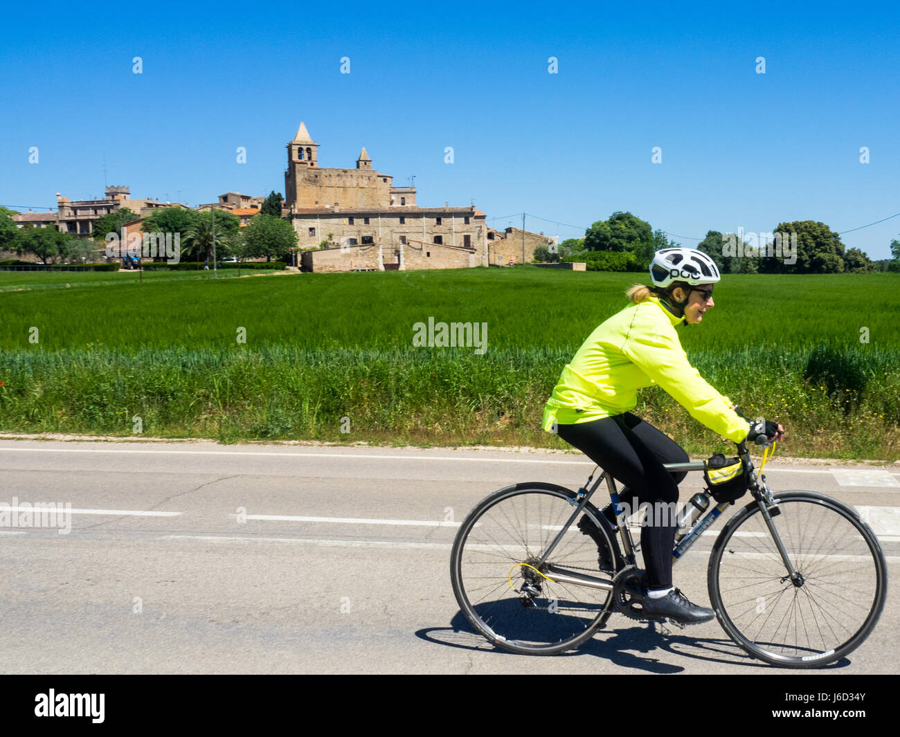 A female touring cyclist riding her titanium bicycle in the countryside ...