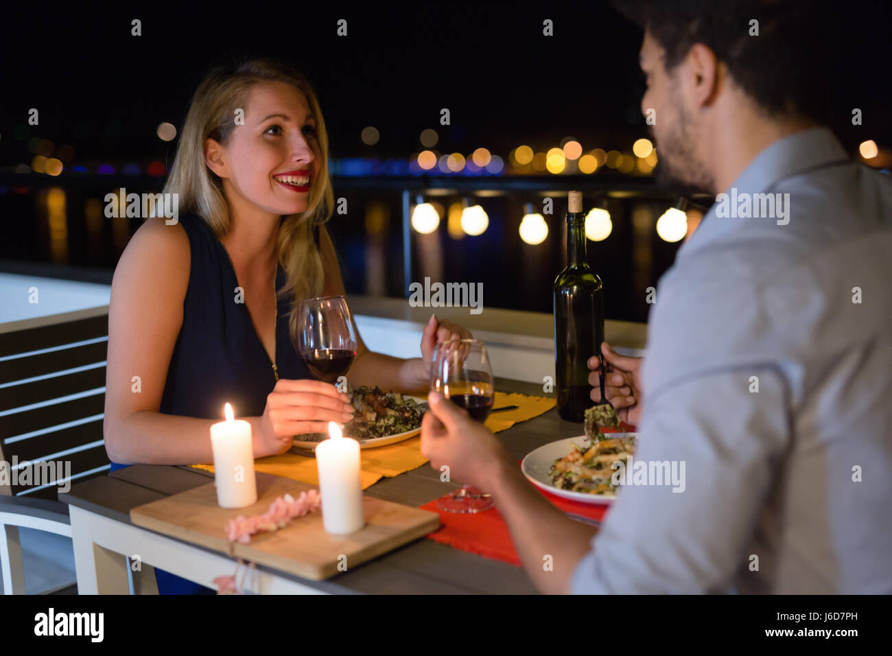 Young beautiful couple having romantic dinner on rooftop Stock Photo ...