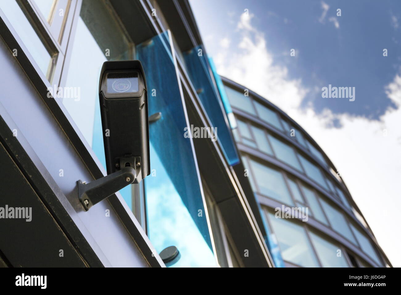 Grey security camera with window reflecting blue sky clouds Stock Photo ...