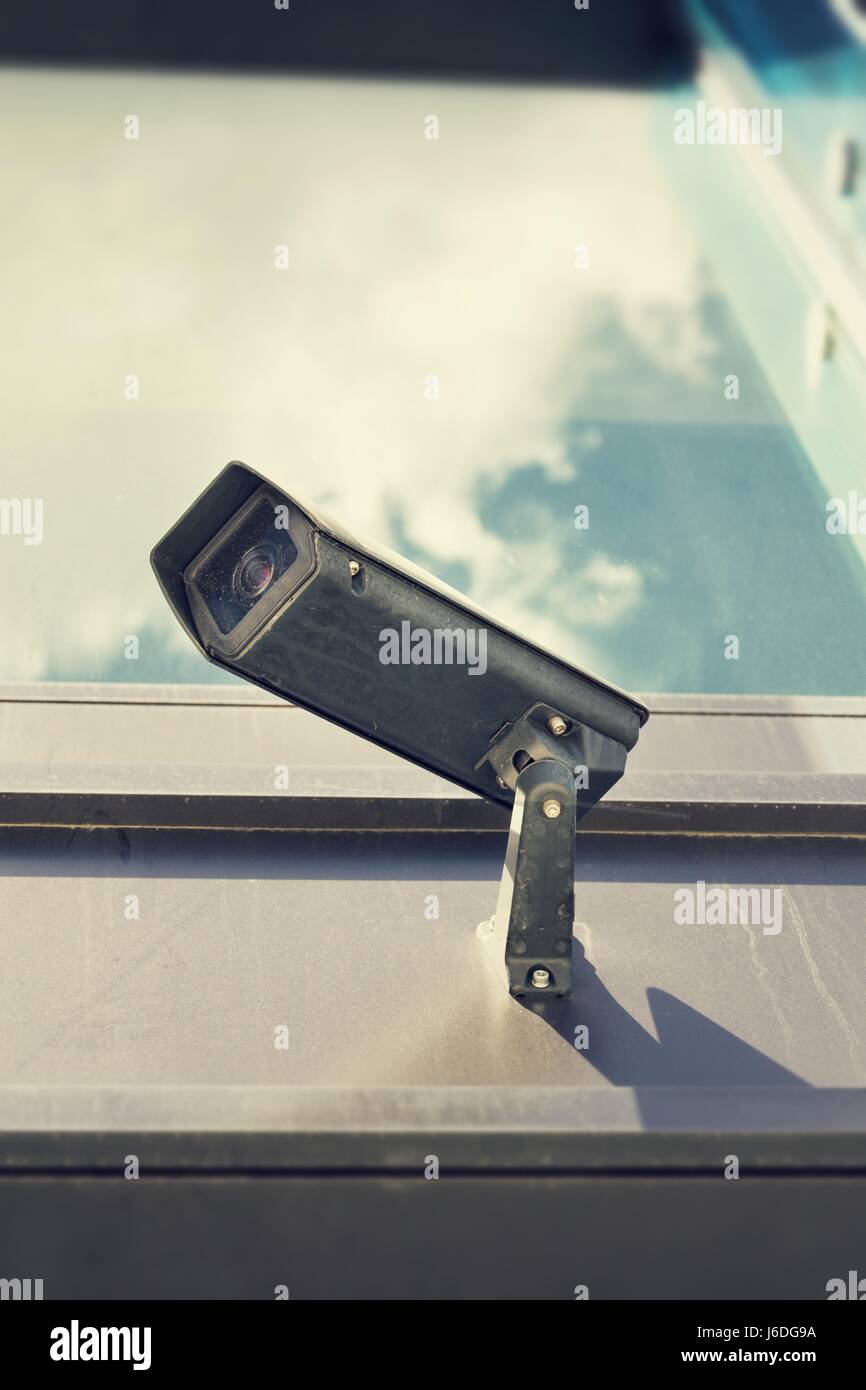 Grey security camera with window reflecting blue sky clouds Stock Photo ...