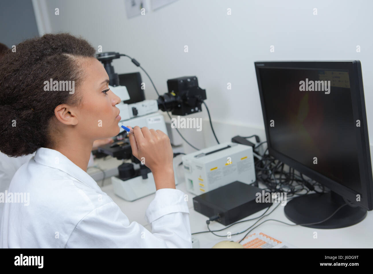 Female scientist looking at computer screen Stock Photo - Alamy