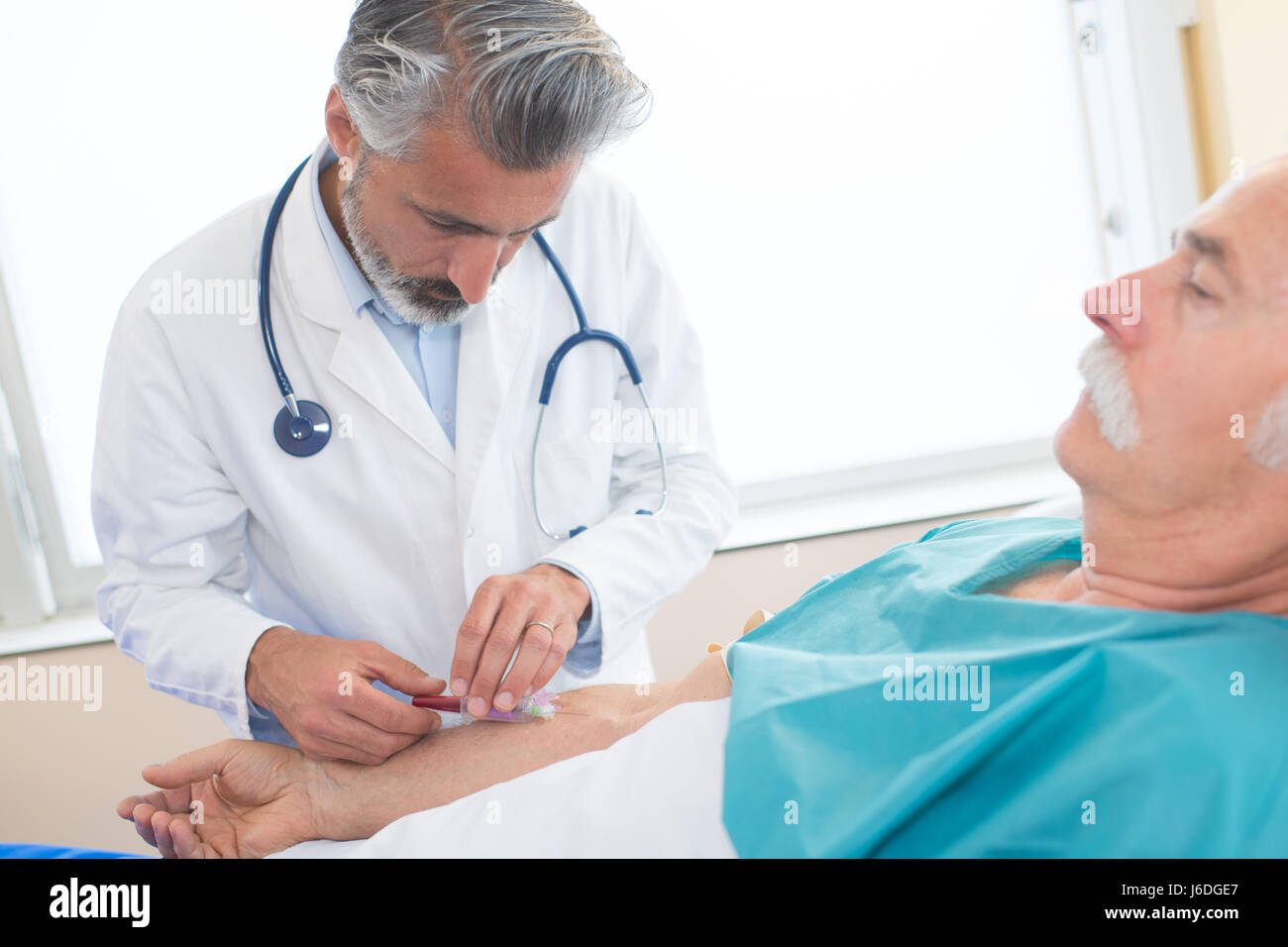 Doctor taking blood from patient's arm Stock Photo - Alamy