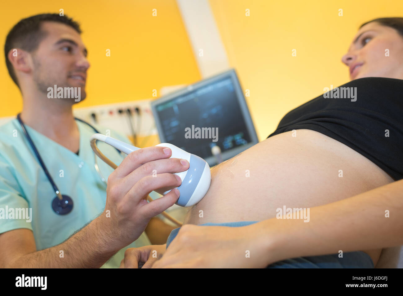 Gynecologist scanning pregnant lady's bump Stock Photo - Alamy